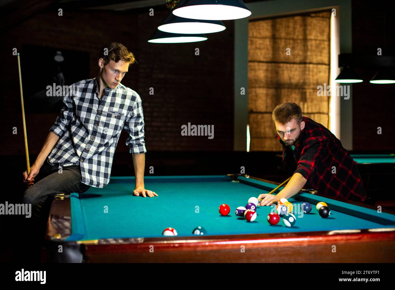 Medium shot guy sitting pool table Stock Photo - Alamy