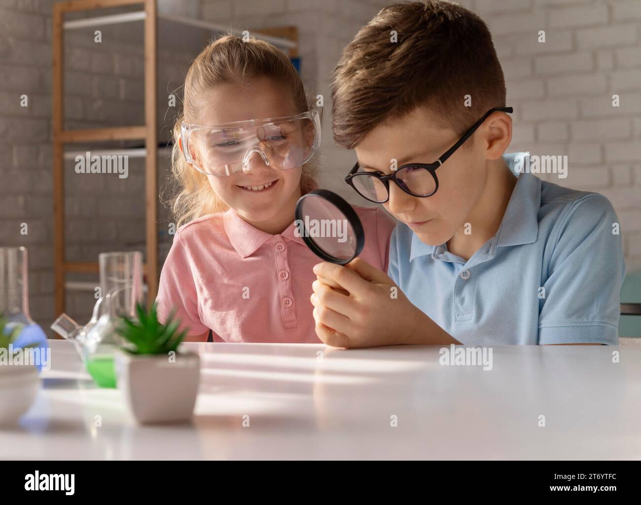 Medium shot kids with magnifying glass Stock Photo - Alamy