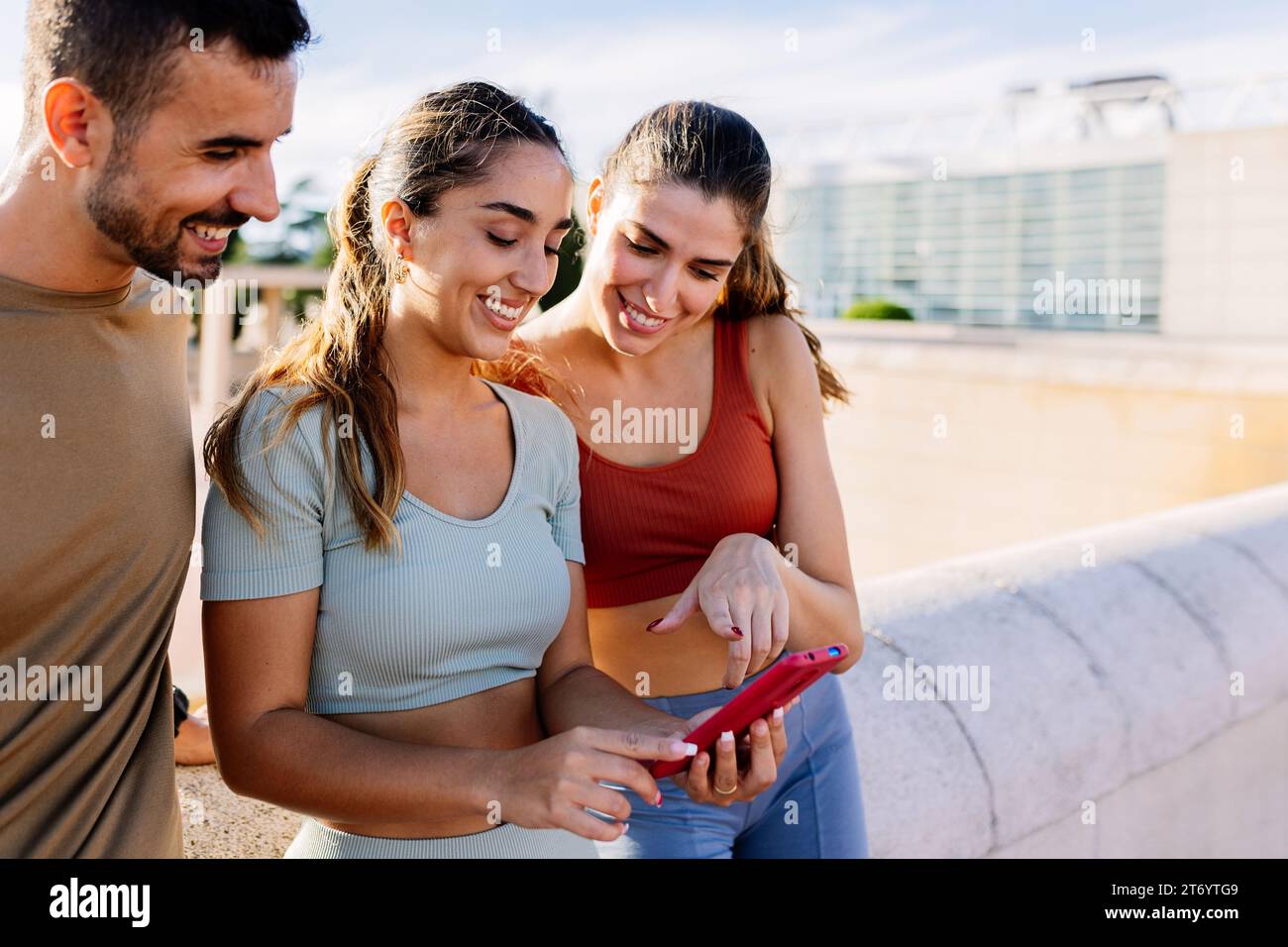 Young group of healthy people using mobile phone together outdoor Stock Photo - Alamy