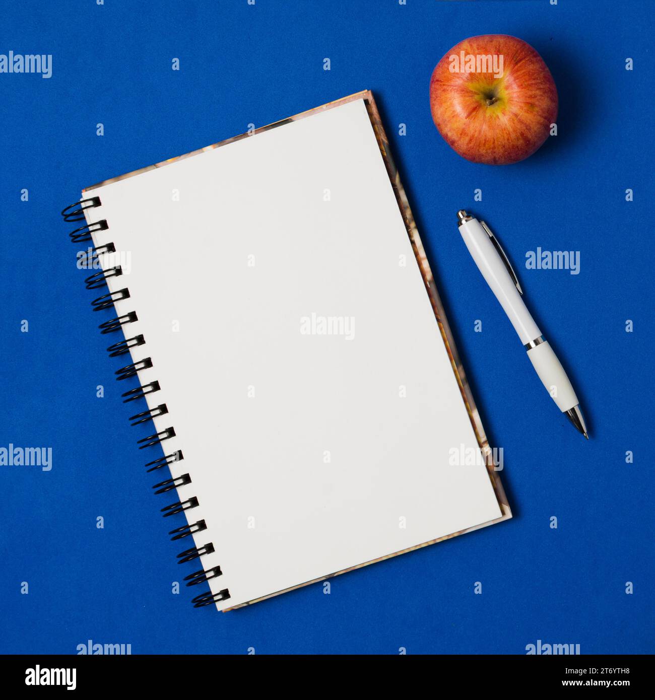 Mockup notepad with apple dark blue background Stock Photo - Alamy