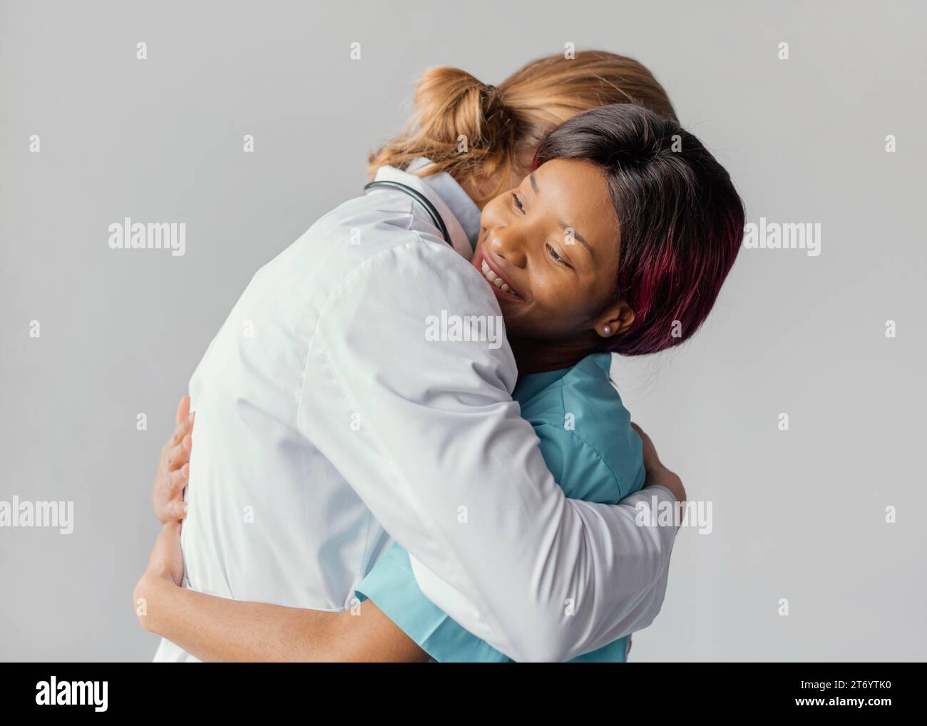 Medium shot doctors hugging Stock Photo - Alamy