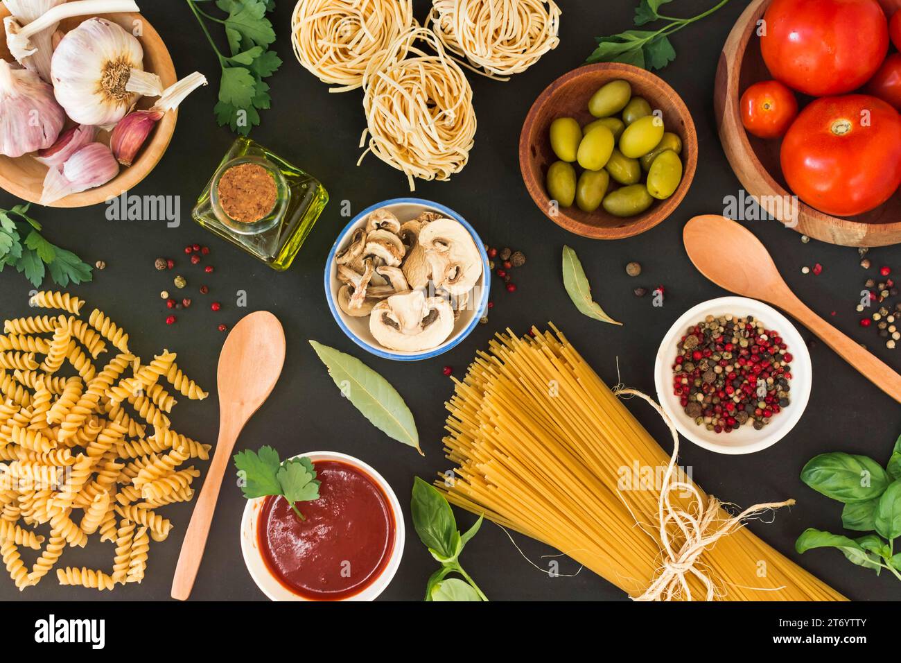 Overhead view raw pasta with ingredients black background Stock Photo ...