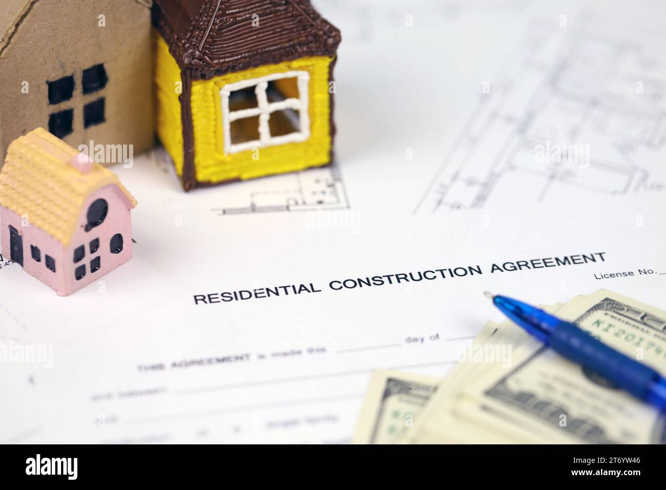 Residential construction agreement ready to sign with small toy houses ...