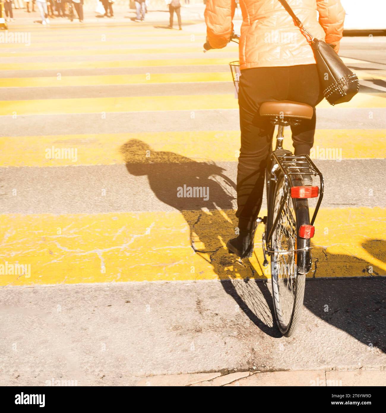 Rear view woman riding bicycle street Stock Photo - Alamy