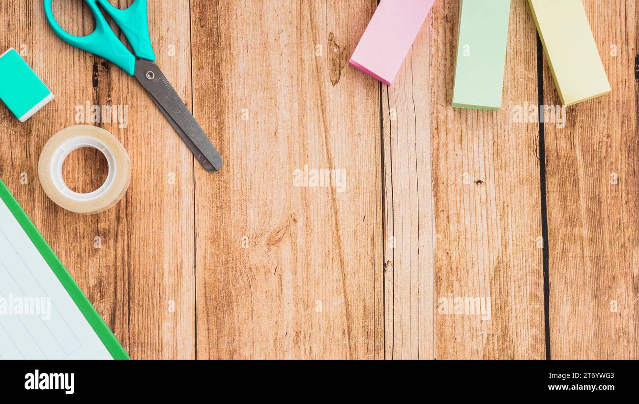 Sticky notes scissor tape eraser wooden table Stock Photo - Alamy
