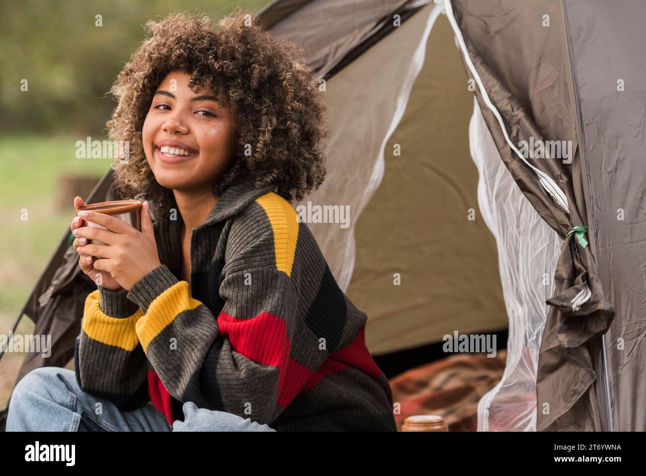 Smiley woman camping outdoors with tent Stock Photo - Alamy