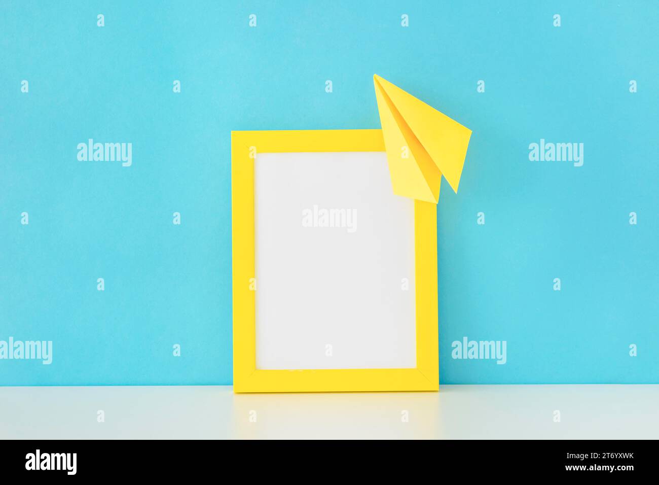 Yellow frame paper plane front blue wall Stock Photo - Alamy