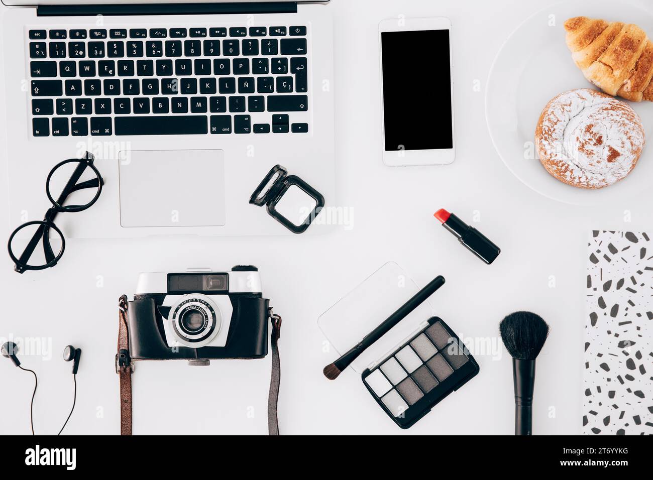 Camera laptop mobilephone cosmetics product baked pastry white desk ...