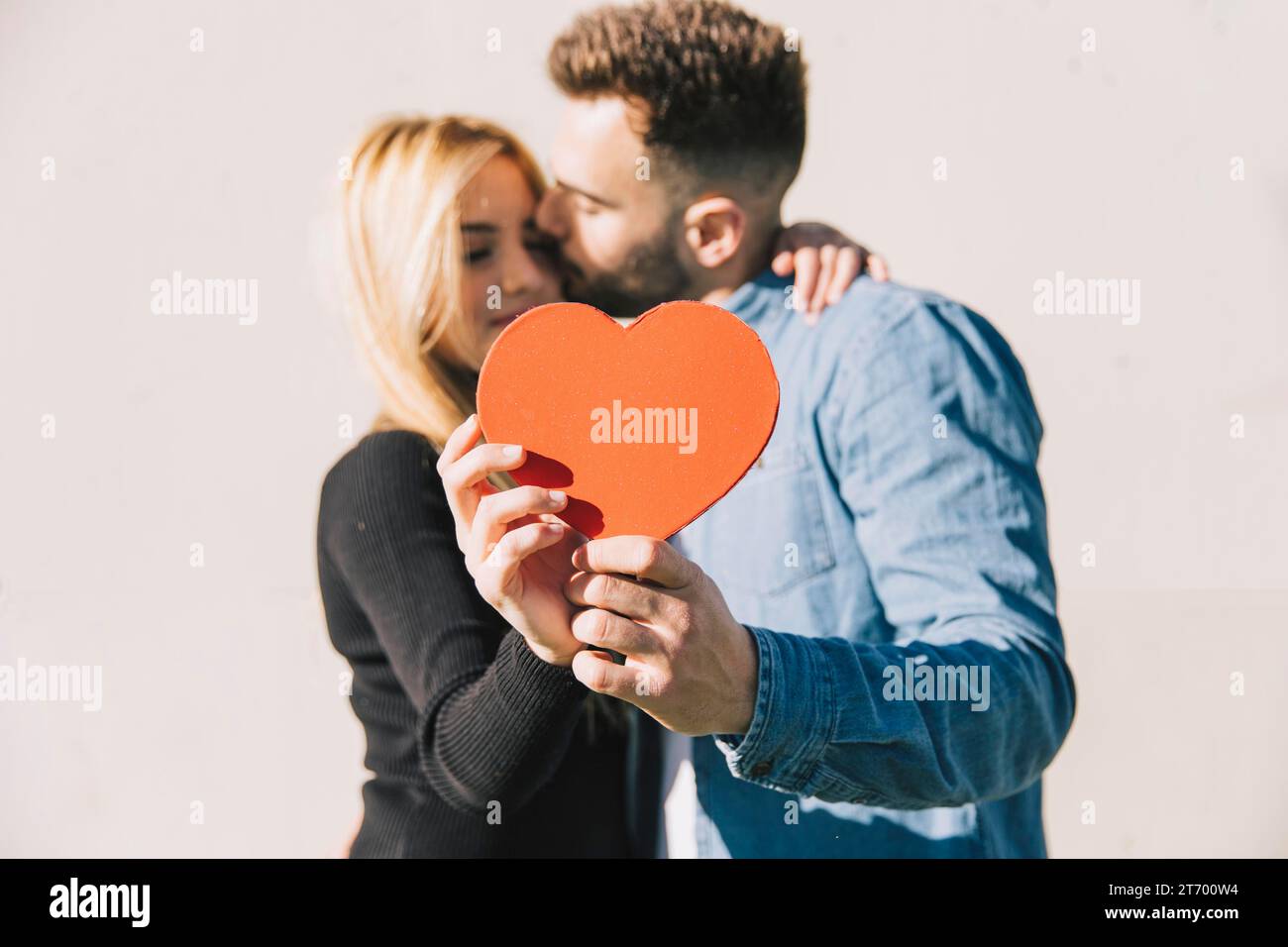 Enamored couple posing with red heart Stock Photo - Alamy