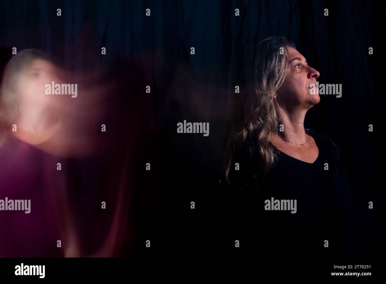 Woman doing in abstract performance with blurred movements. Dark ...