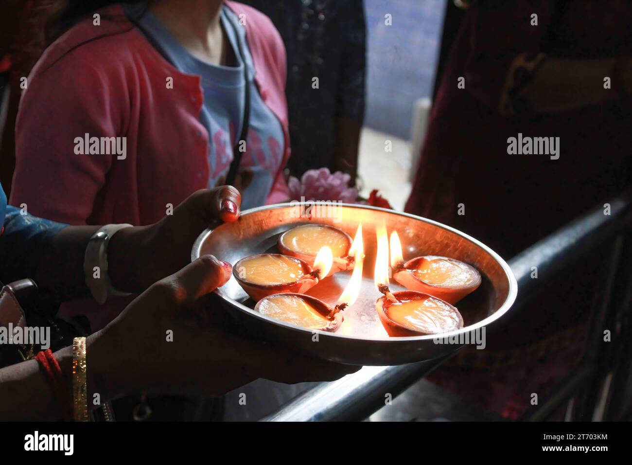One of the Hindu women carries some sacred lamps, to offer to the ...