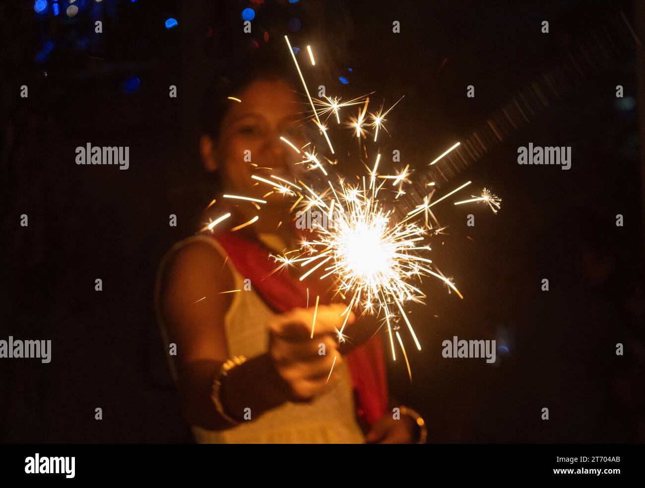 November 12, 2023: Woman light phuljhari or stick firecracker, on the ...