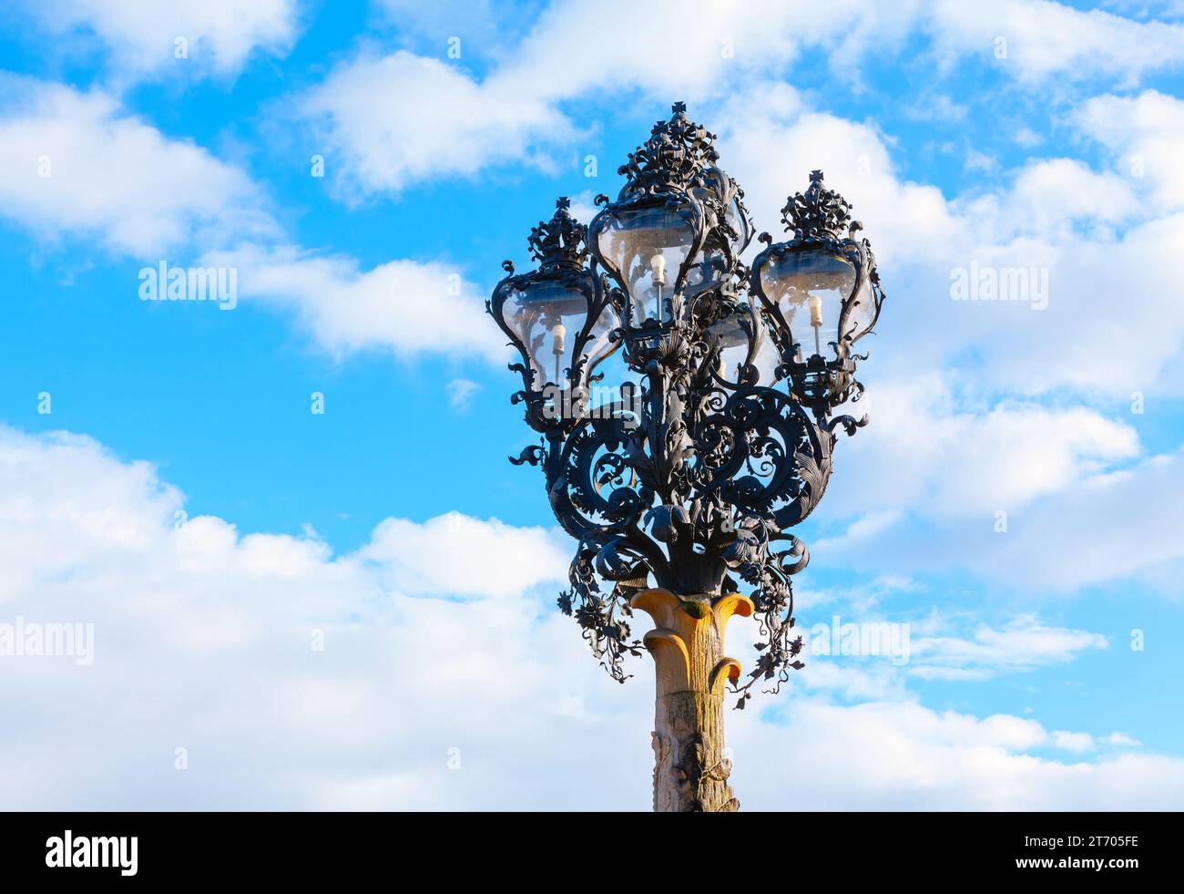 Street lamp against the blue sky with clouds . Lamp base features ...