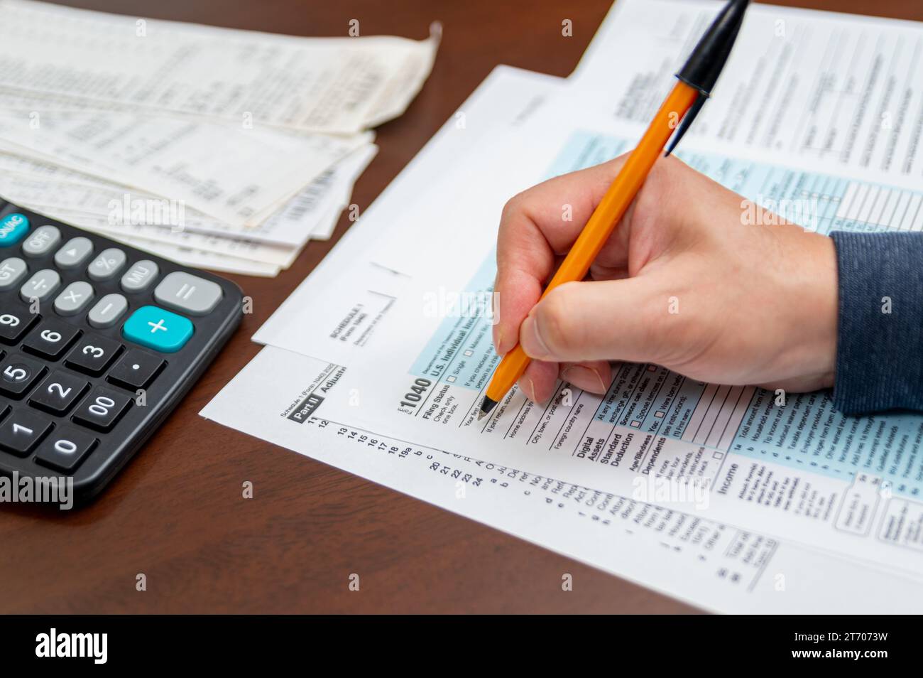 A man organizing individual income tax return form 1040 and receipts ... A man organizing individual income tax return form 1040 and receipts ...