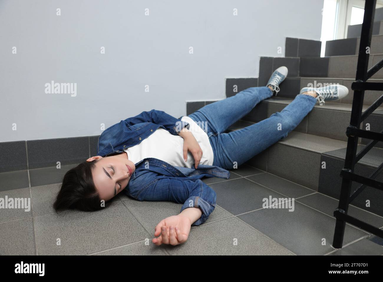 Unconscious woman lying on floor after falling down stairs indoors ...