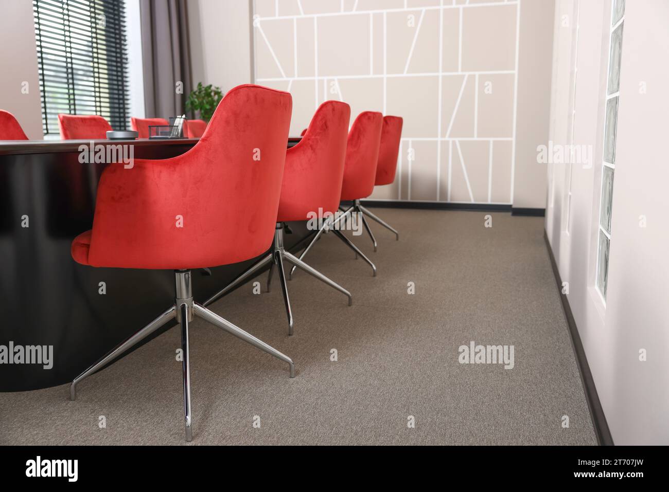 Stylish red office chairs and large table in empty conference room ...