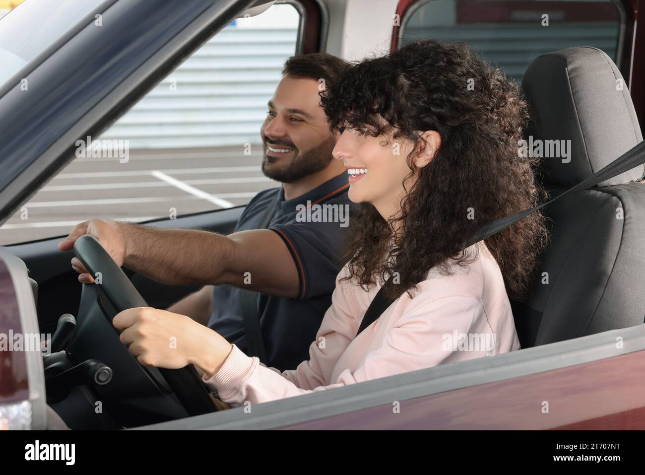 Driving school. Happy student during lesson with driving instructor in ...