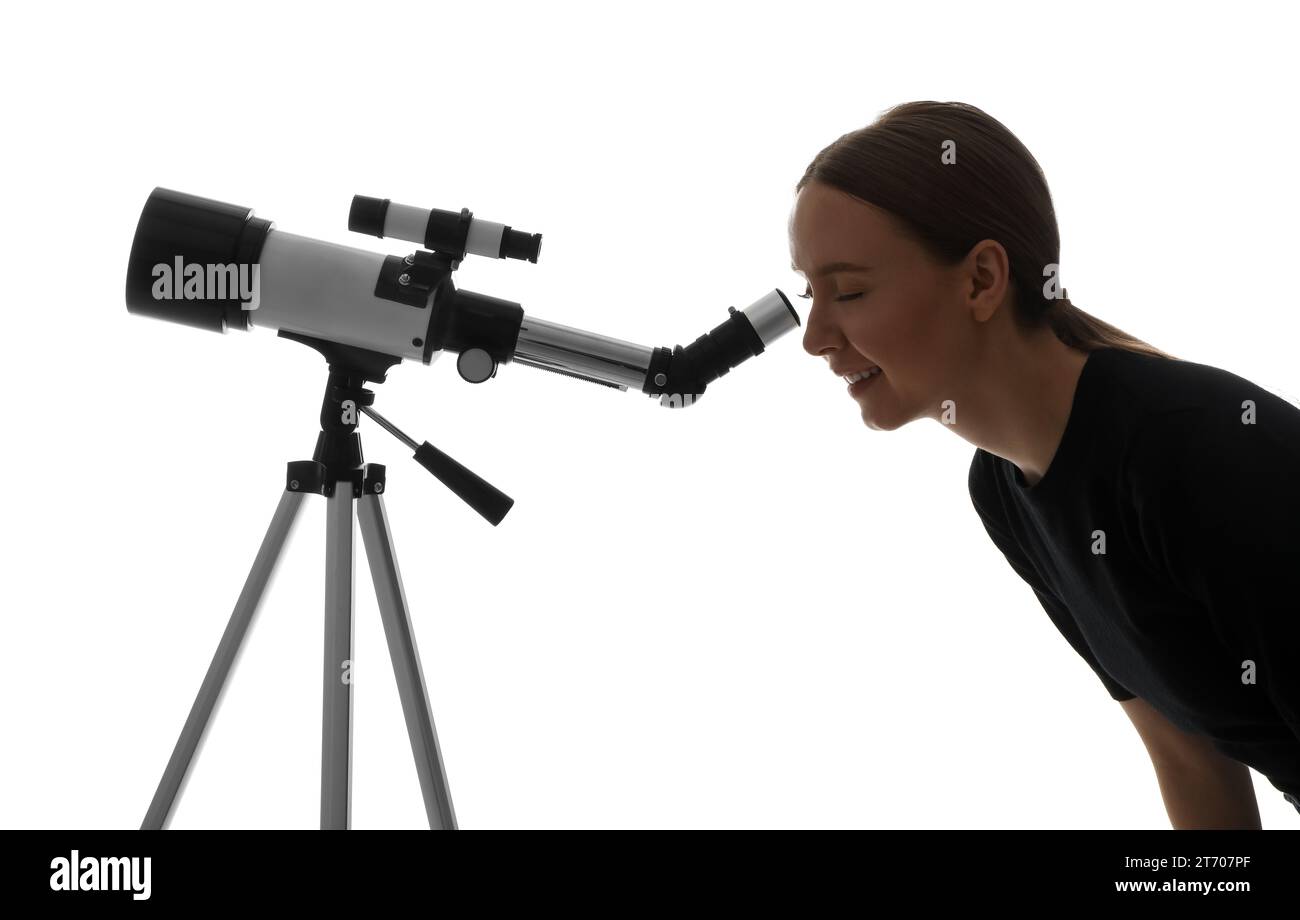 Young astronomer looking at stars through telescope on white background ...