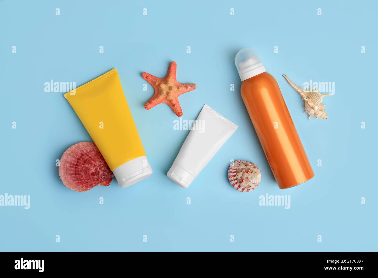 Flat lay composition with sunscreen on light blue background. Sun ...