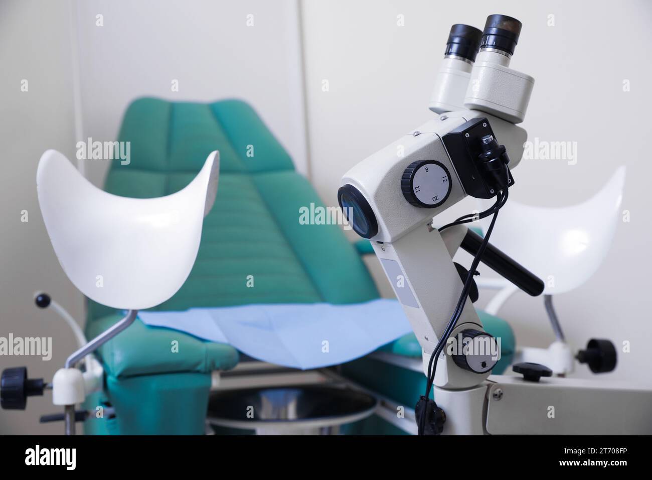 Modern binocular colposcope near gynecological chair in clinic Stock ...
