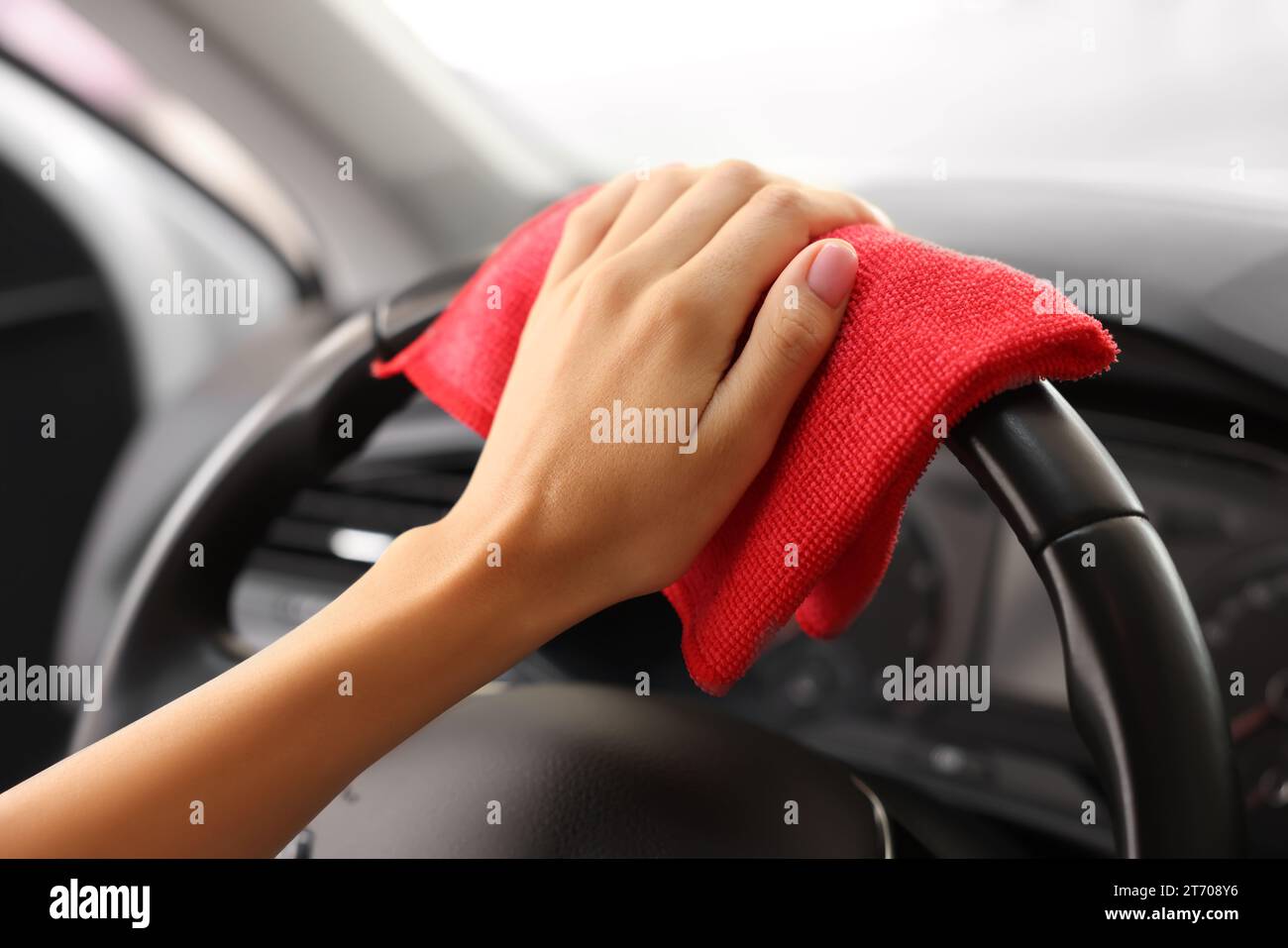 Woman cleaning steering wheel with rag in car, closeup Stock Photo - Alamy