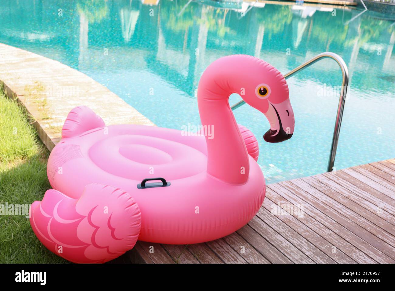 Float in shape of flamingo on wooden deck near swimming pool at luxury ...