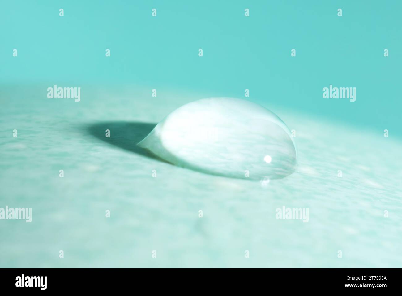 Macro photo of water drop on turquoise background Stock Photo - Alamy