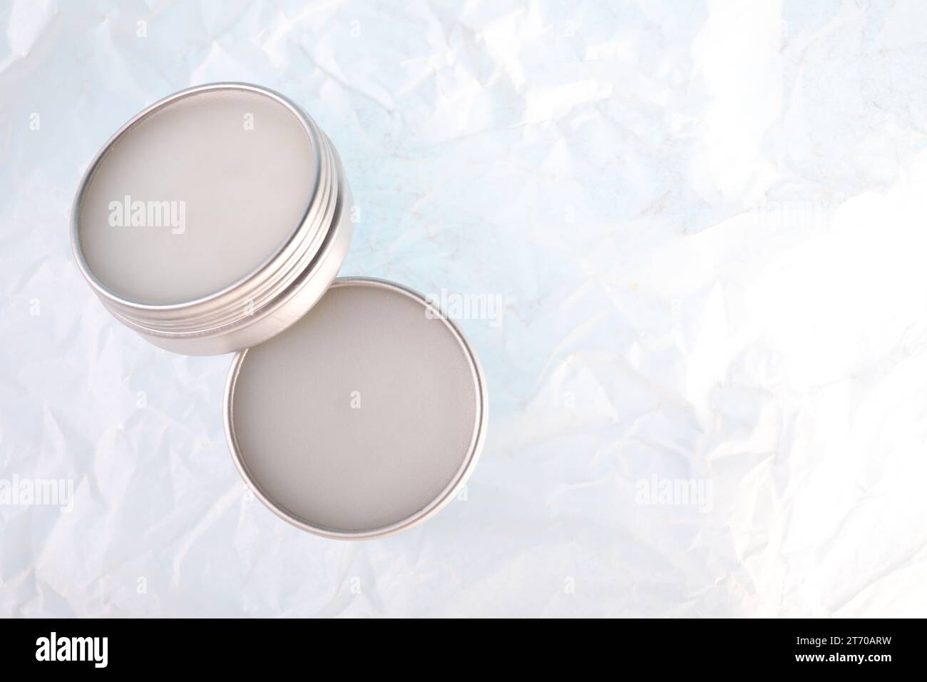 Lip balms on white crumpled paper, top view. Space for text Stock Photo ...