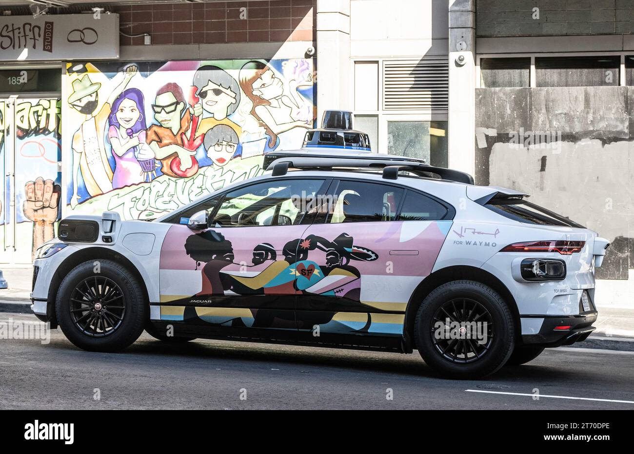 A driverless Waymo car passes a mural in San Francisco on Sumday ...