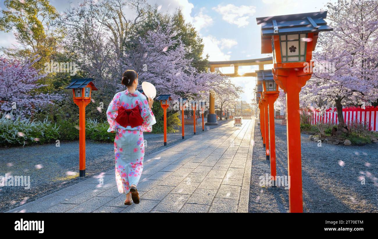 Young Japanese woman in traditional Yukata dress strolls at Hirano ...