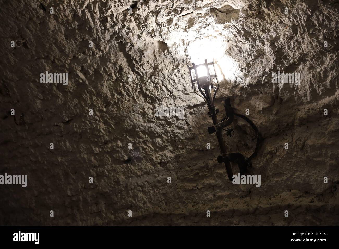 Lighted medieval castle torch hanging on a stone wall, vintage objects ...