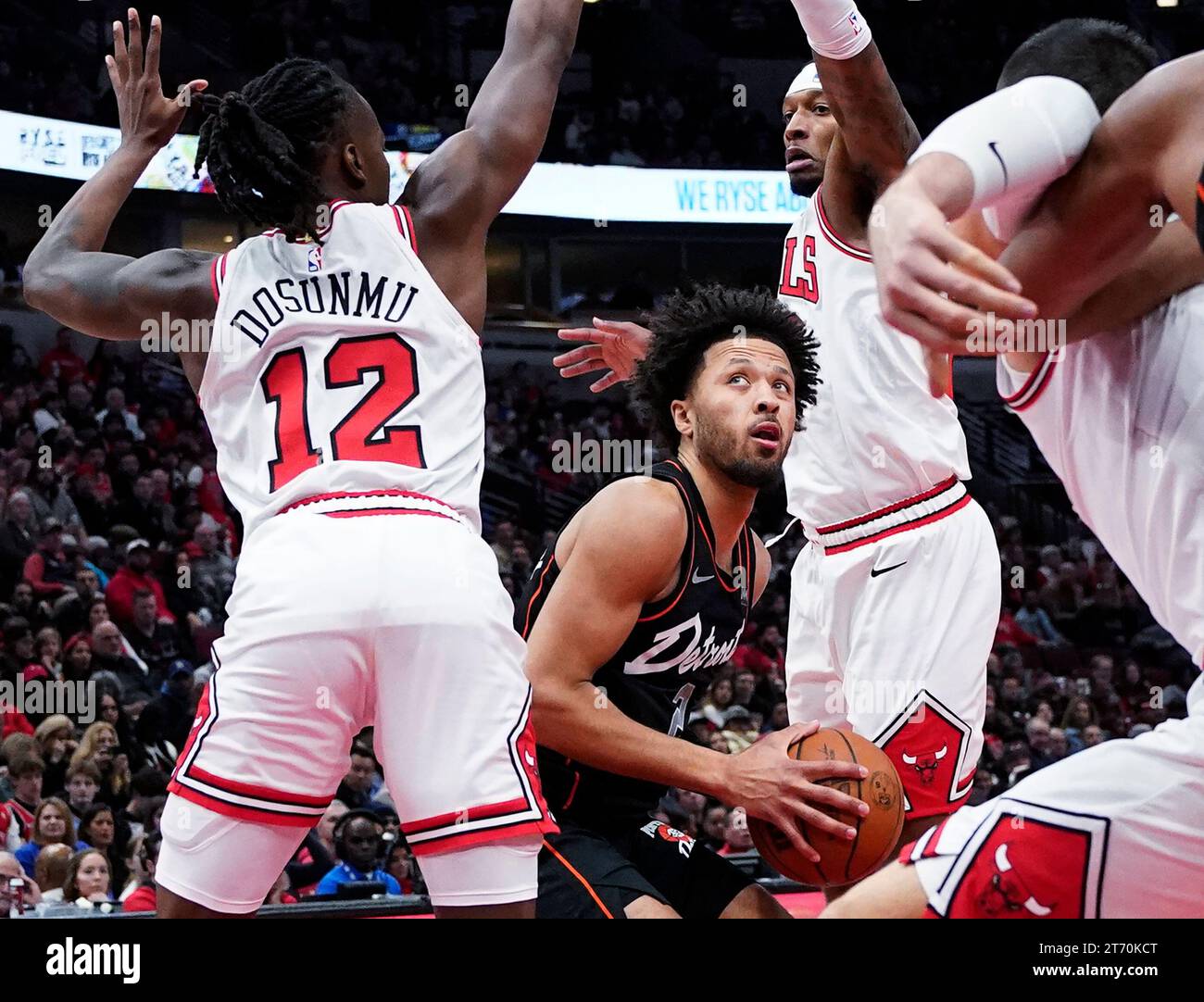 Detroit Pistons guard Cade Cunningham, center, looks to the basket as ...