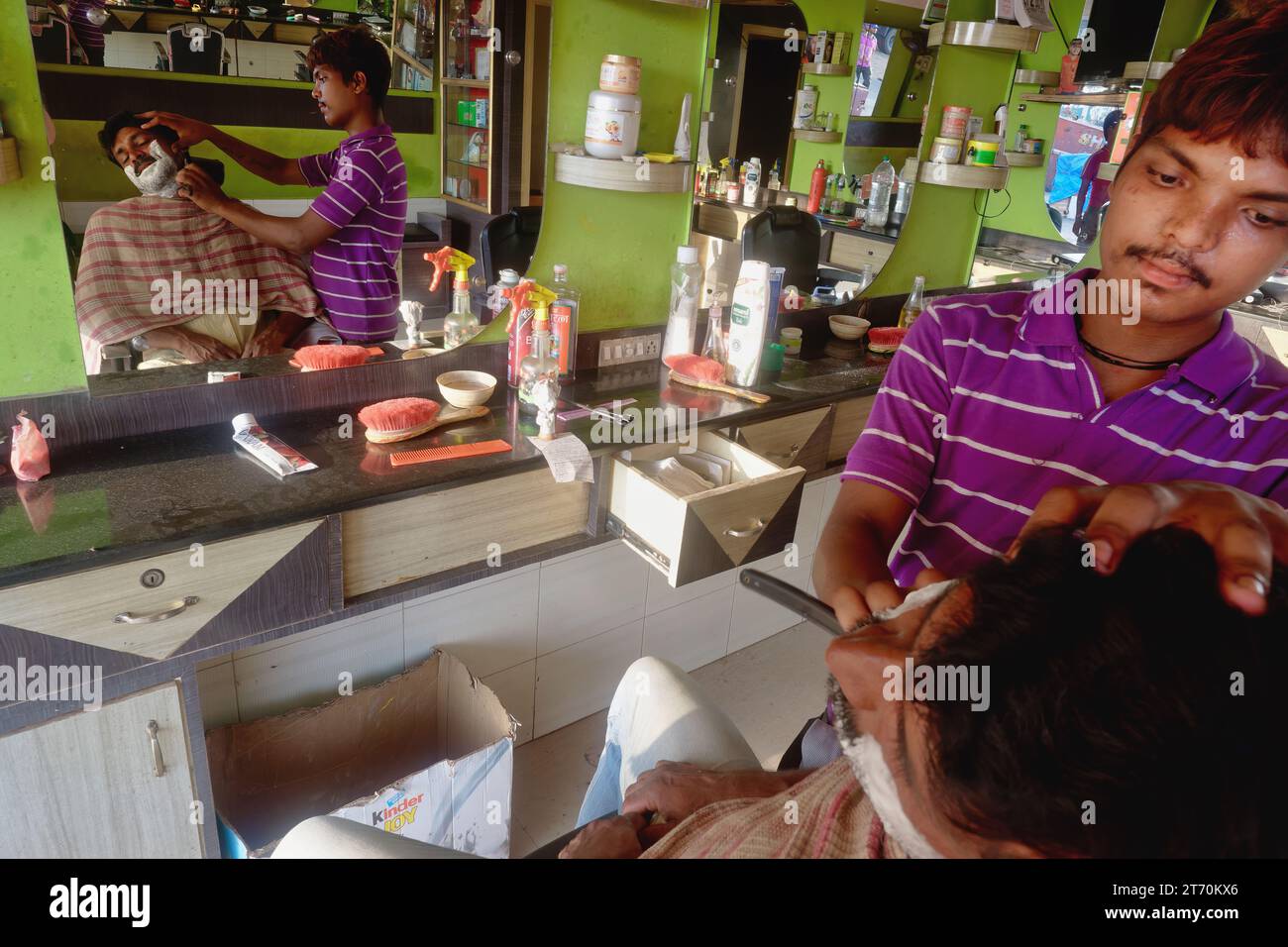 A barber shaves a customer in his barber's shop in the Old Port area of ...