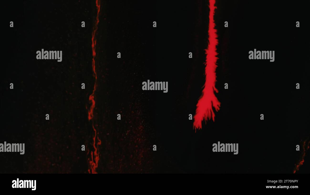 Paint drip ink pouring red dye spill flow on black Stock Photo - Alamy