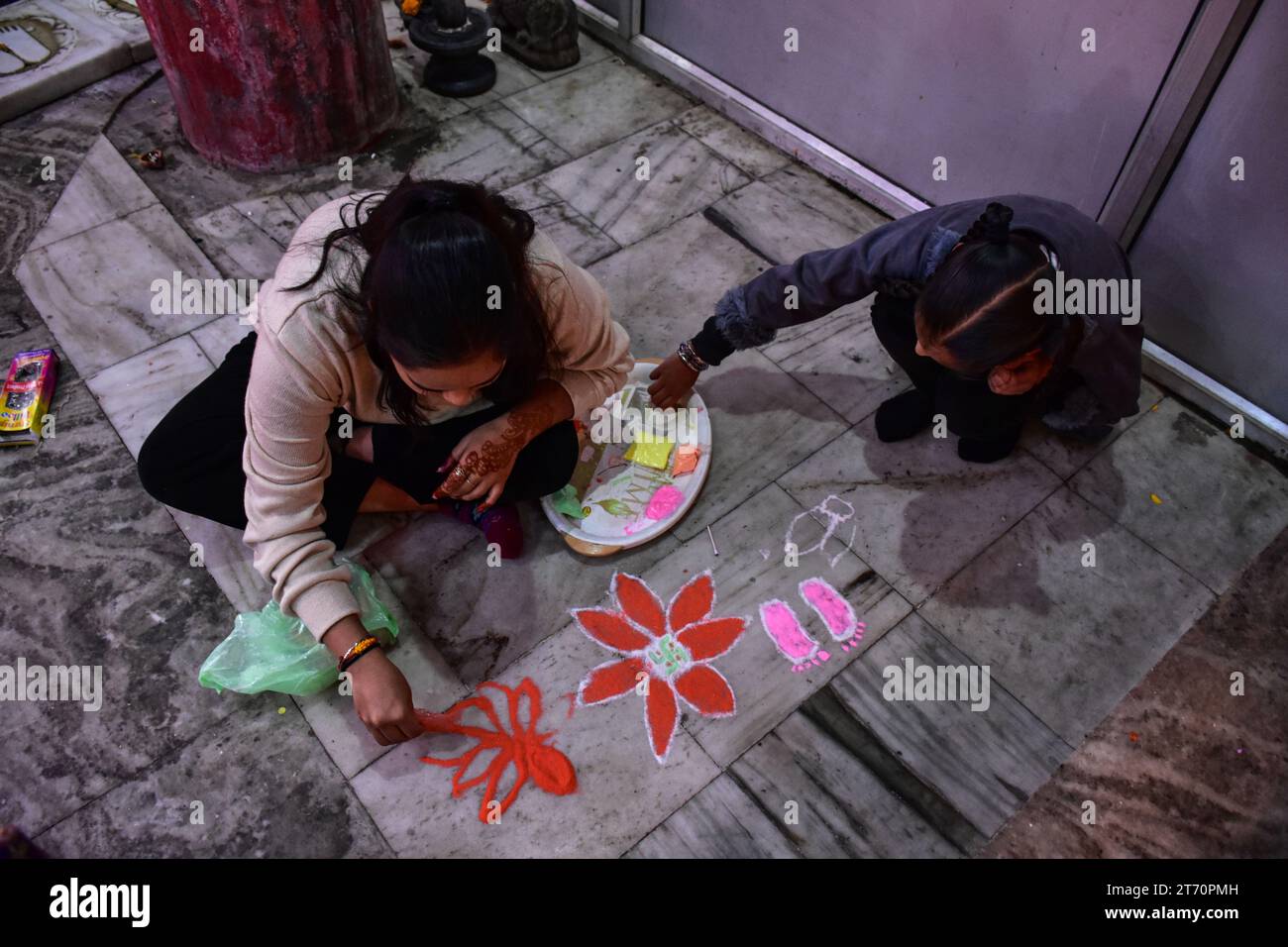Hindu devotees prepare a decorative rangoli design inside the temple on ...