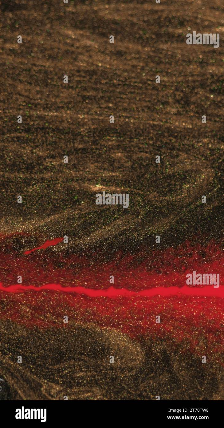 Glitter paint spill fluid background red golden Stock Photo - Alamy