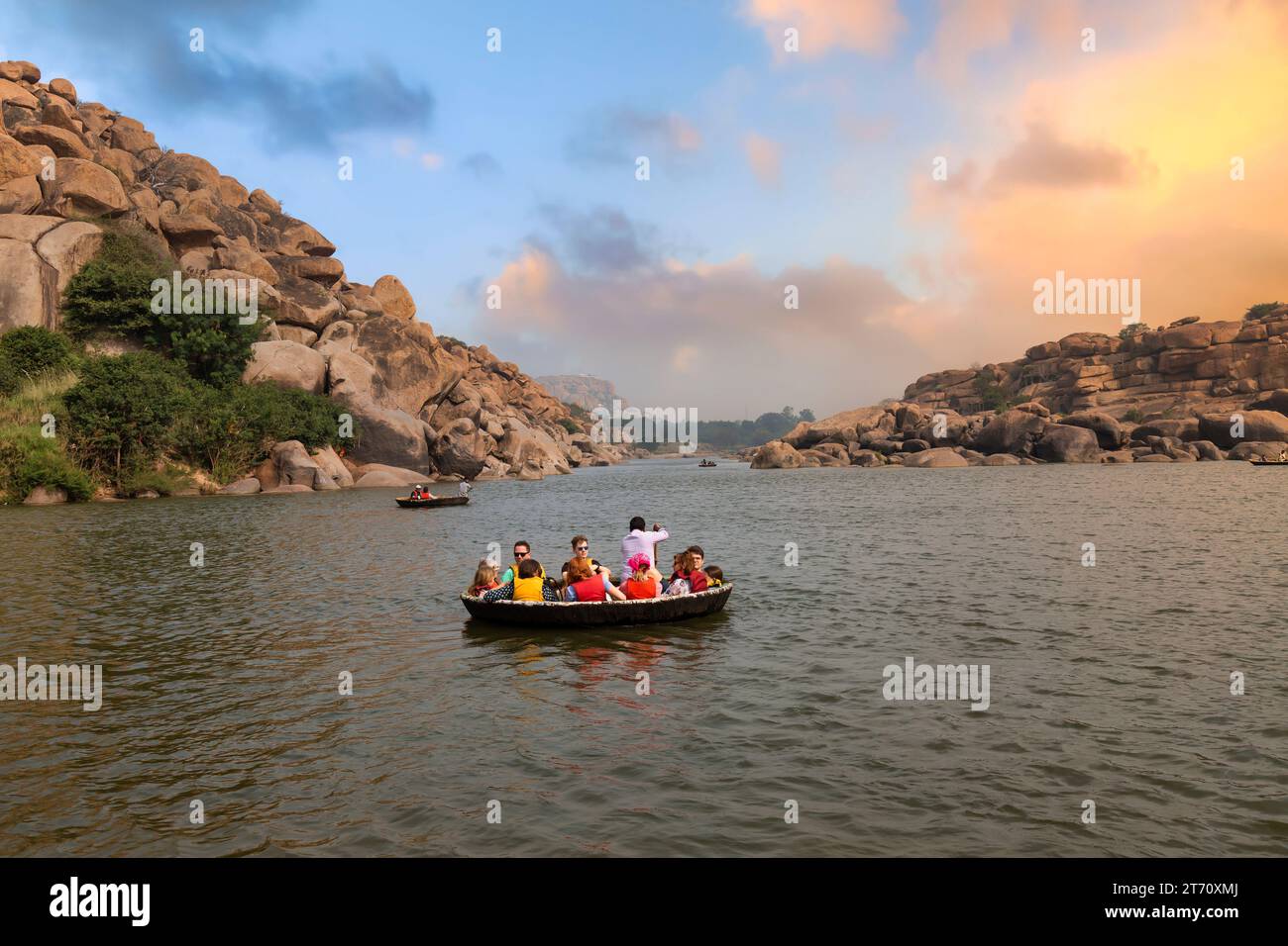Tourist enjoy coracle boat ride on Tungabhadra river at Hampi Karnataka ...