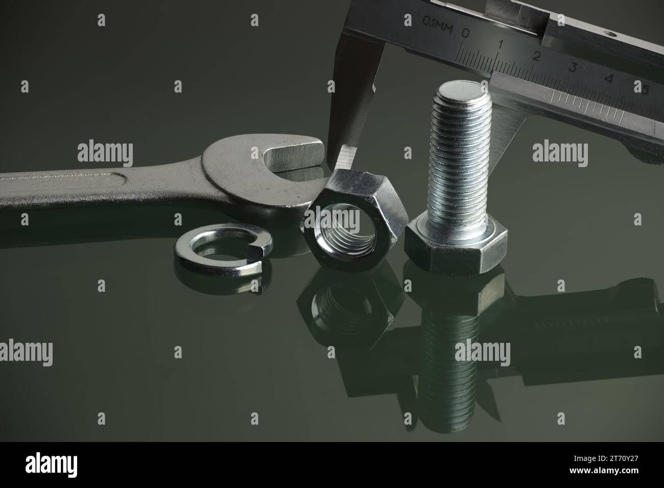 Close-up view of a mechanical setup involving a wrench and caliper, nut ...