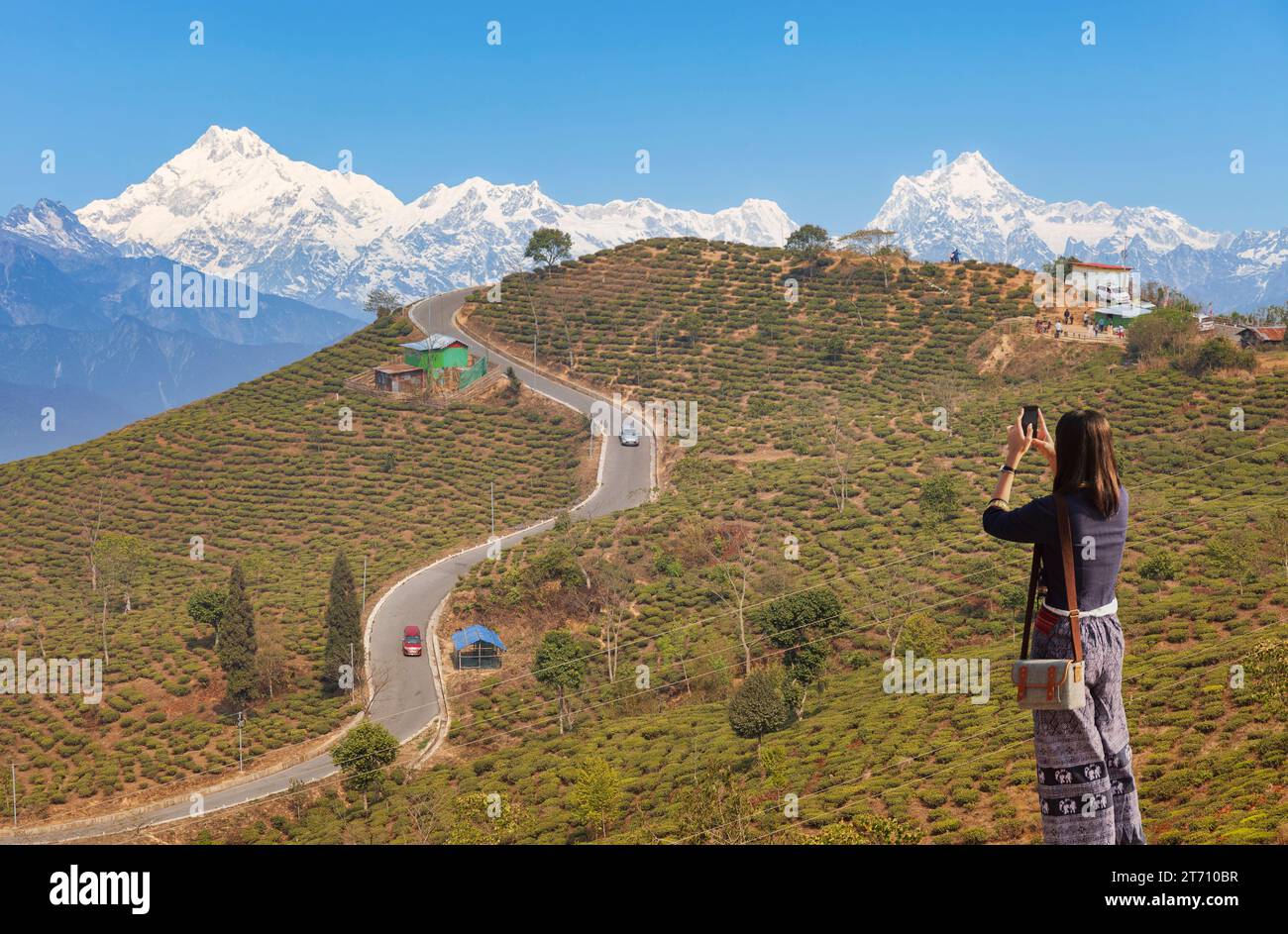 Female tourist takes photographs of the scenic landscape with the ...