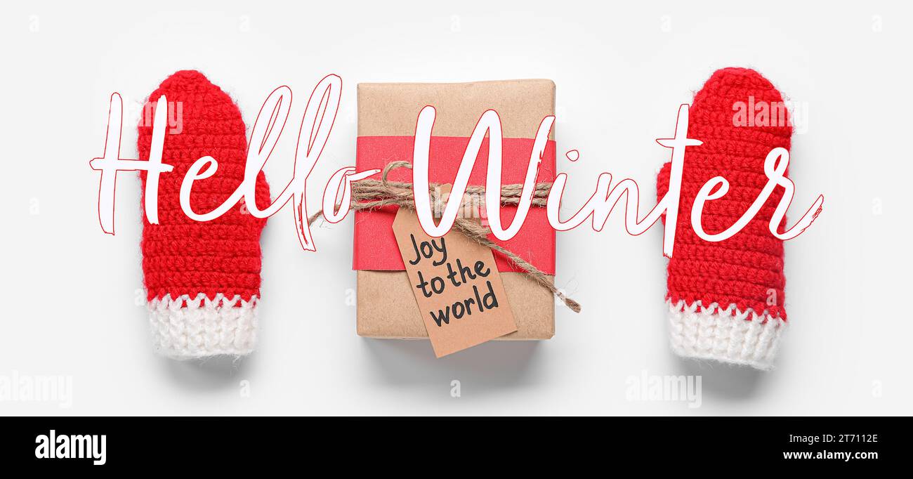 Gift box and warm knitted mittens on white background. Hello winter ...