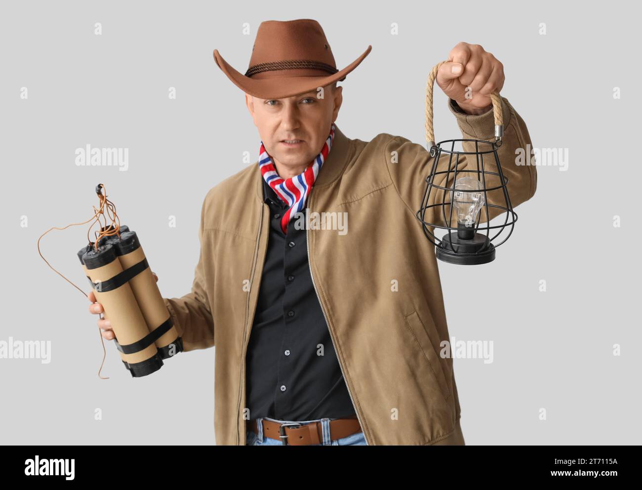 Mature cowboy with explosive and lantern on light background Stock ...