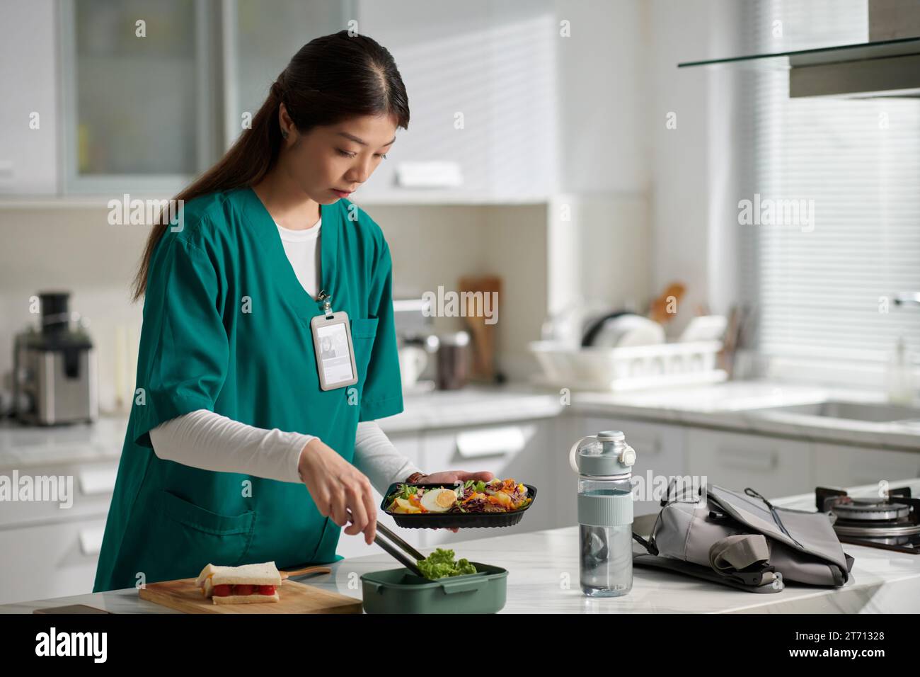 Medical nurse preparing containers with food to have lunch at work ...