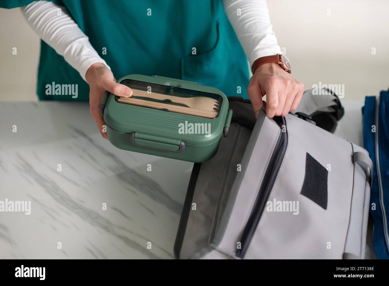 Medical nurse putting lunchbox in bag when packing for work or college ...