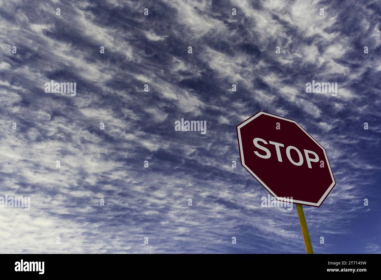 Red STOP sign, with yellow wood pole with coudy sky background in ...