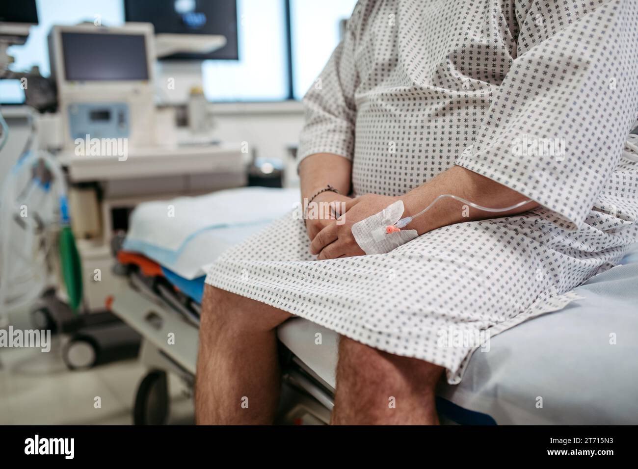 Close up of overweight patient in hospital gown waiting for medical ...