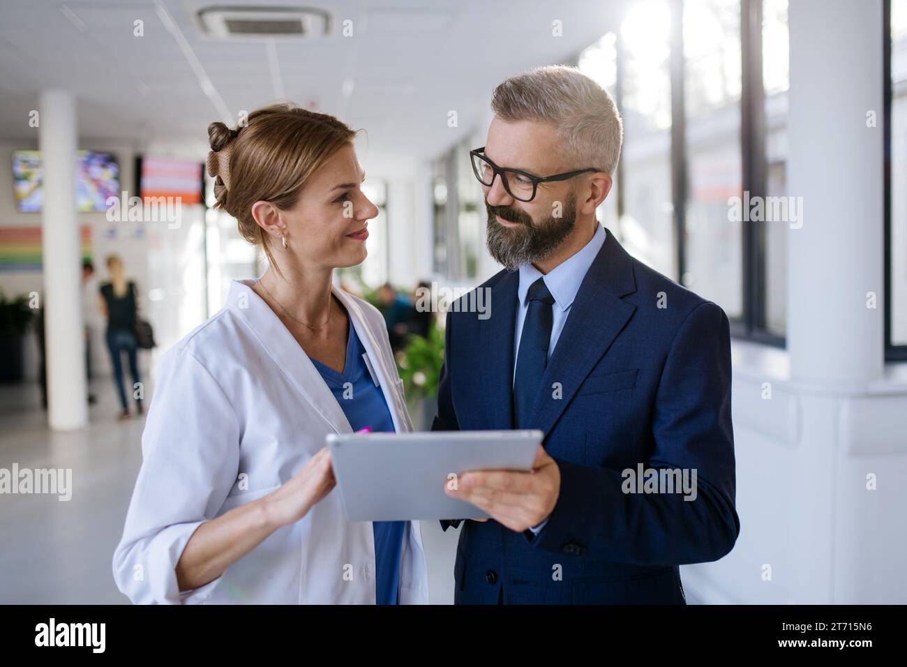 Pharmaceutical sales representative talking with female doctor in ...