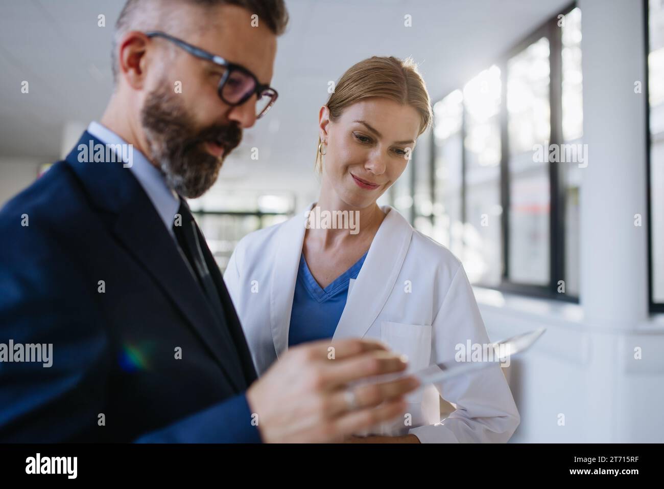 Pharmaceutical sales representative talking with female doctor in ...