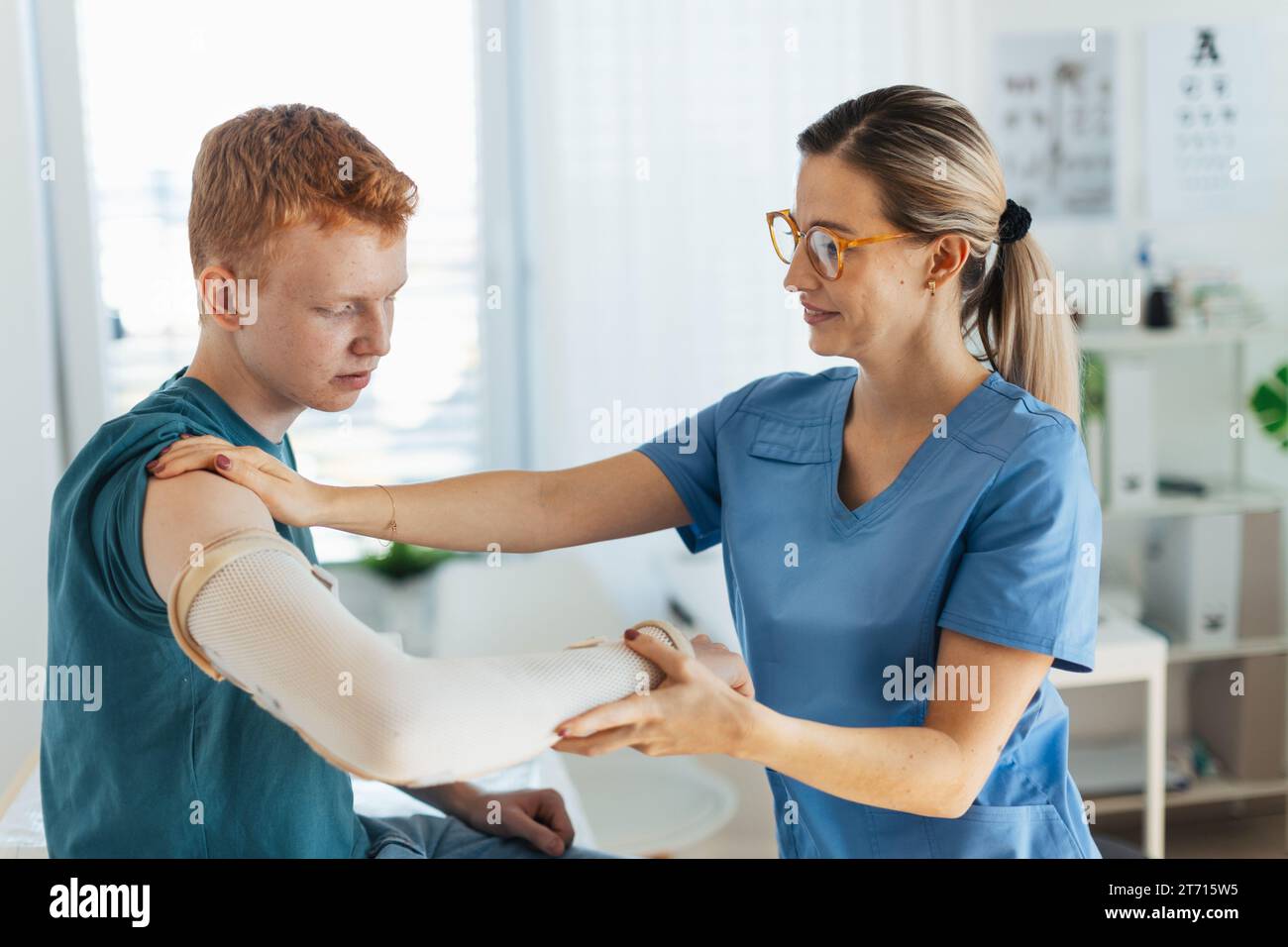 Doctor checking the orthopedic cast, brace on a teenage patient's ...