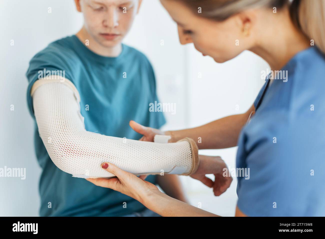 Doctor checking the orthopedic cast, brace on a teenage patient's ...