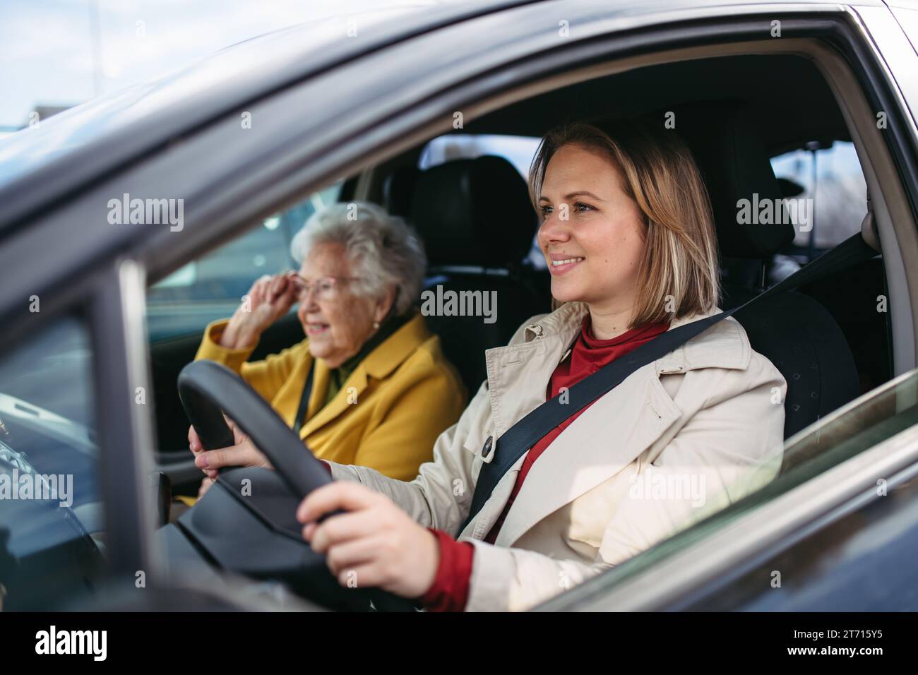 Granddaughter driving her elderly grandmother in the car, taking her to ...